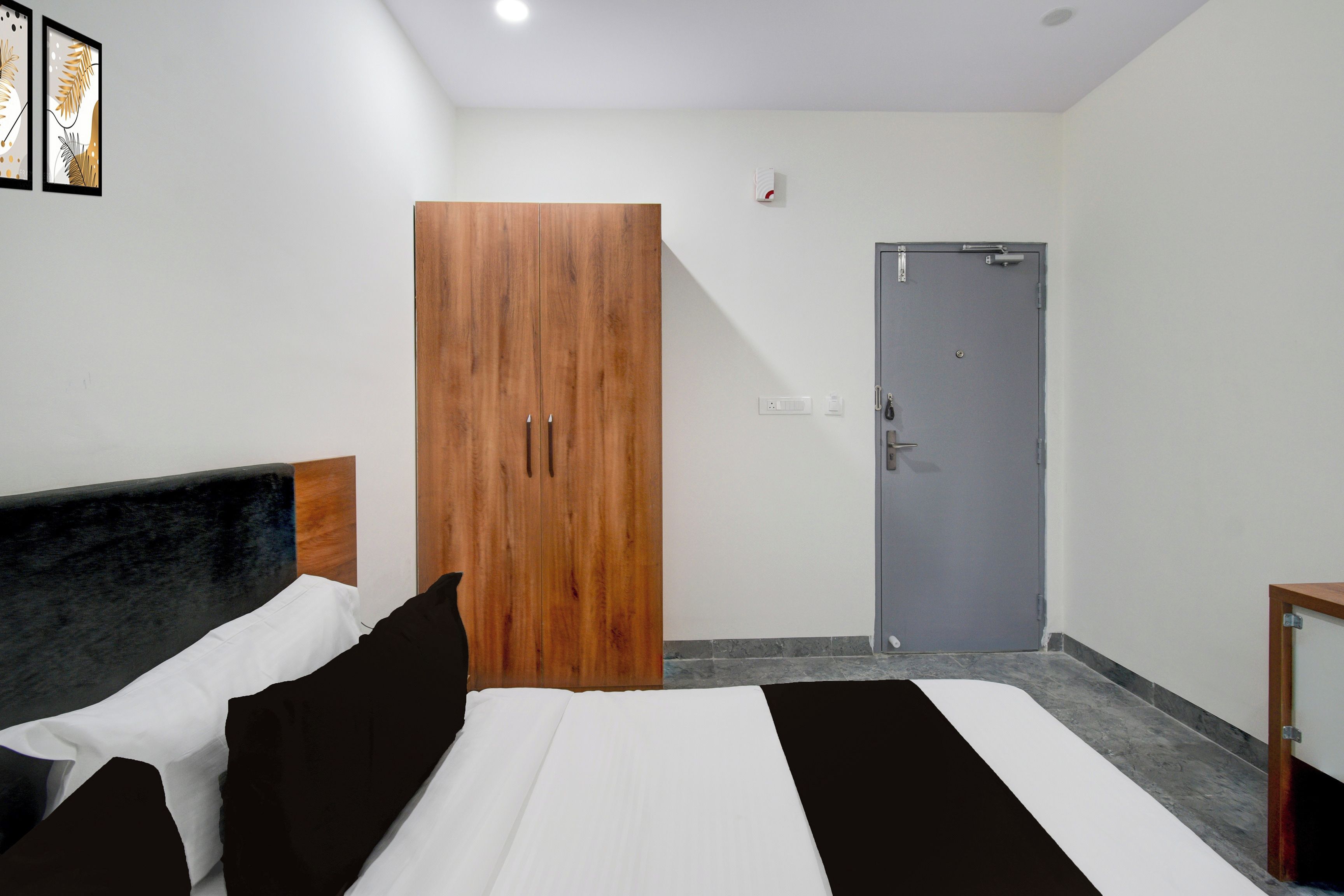 Quarto de hotel com cama, guarda-roupa e porta.