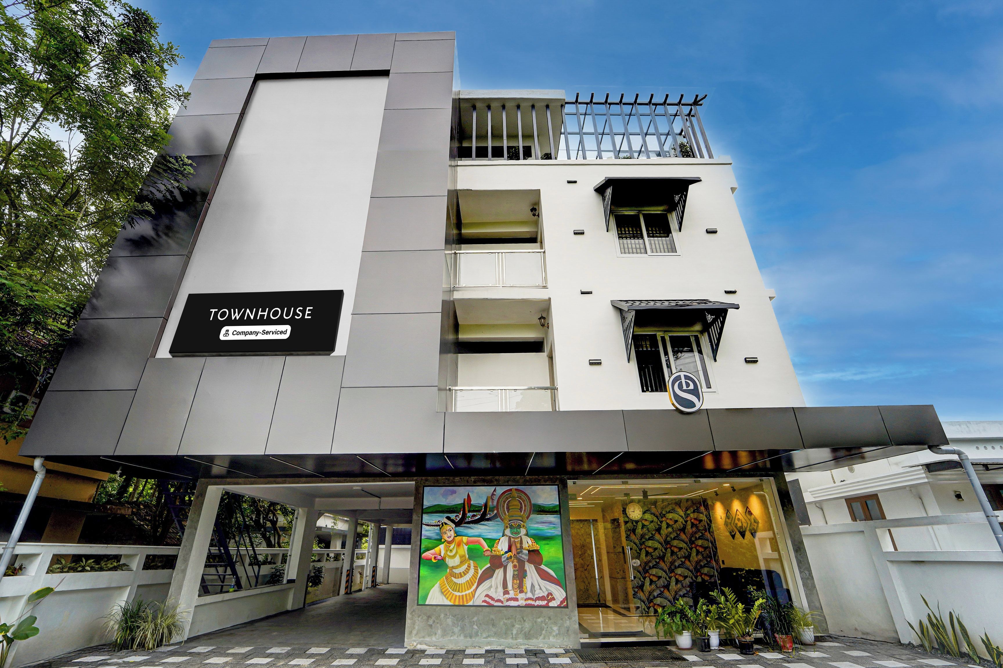 Um edifício moderno com uma placa indicando 'TOWNHOUSE Company-Serviced'.