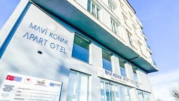 Um hotel moderno com o nome 'Mavi Konak Apart Otel' na fachada.