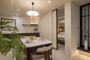 Quarto de hotel moderno com área de refeições, cama e vista da cidade.