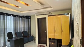 Uma sala de estar moderna com um sofá, cadeiras, uma mesa de centro e um guarda-roupa.