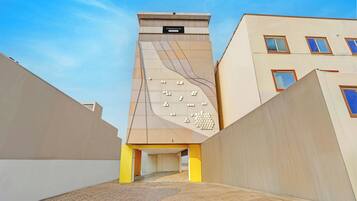 Um edifício moderno com fachada singular, apresentando padrões geométricos e uma placa com a inscrição 'TOWNHOUSE'.