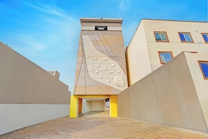 Um edifício moderno com fachada singular, apresentando padrões geométricos e uma placa com a inscrição 'TOWNHOUSE'.