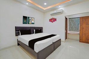 Quarto moderno com cama, obra de arte na parede e aparelho de ar condicionado.