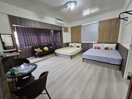 Quarto de hotel moderno com cama, escrivaninha, cadeira e uma janela grande com cortinas.
