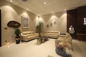 Um interior moderno com um sofá bege, uma mesa de centro e plantas decorativas.