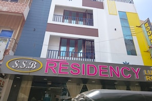 Um edifício de vários andares com uma placa indicando 'S.S.B. Residency', mostrando ser uma propriedade residencial.