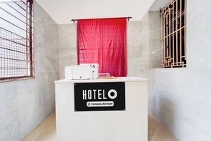 Balcão de recepção de hotel com indicação de serviço corporativo.