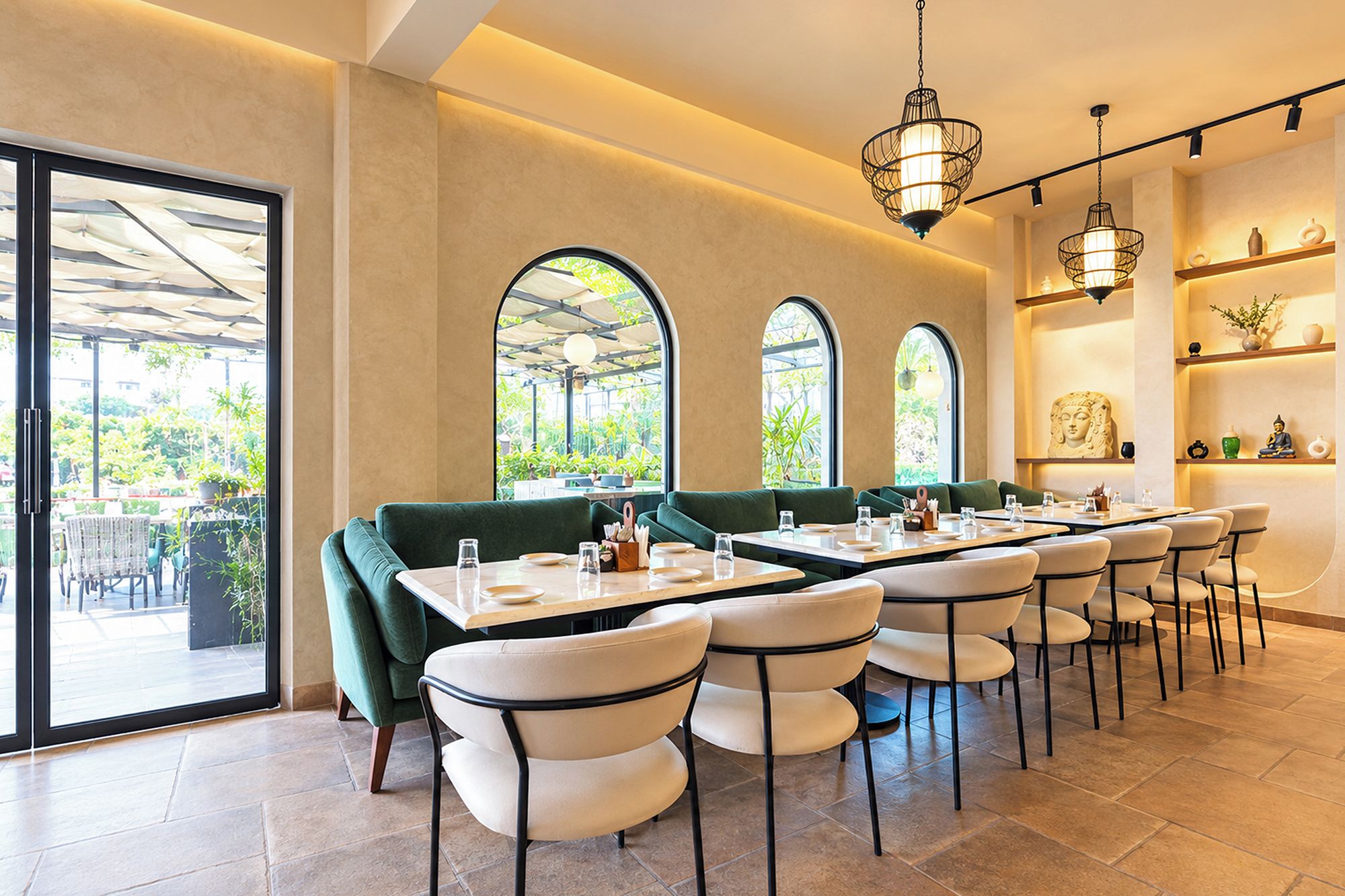 Um restaurante com área de assentos em cabines verdes, mesas brancas e cadeiras pretas.