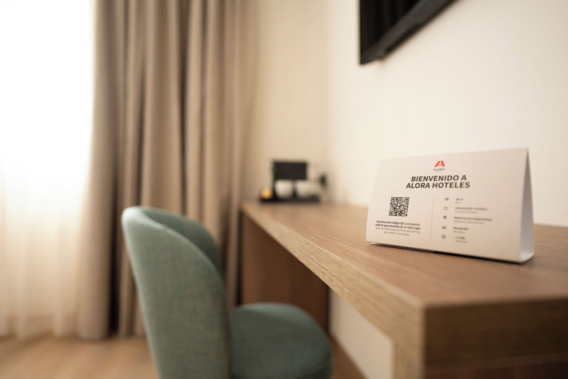 Cartão de boas-vindas de hotel sobre uma mesa de madeira com uma cadeira.