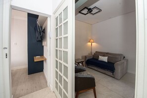 Quarto com sofá, luminária, mesa pequena e cadeira.
