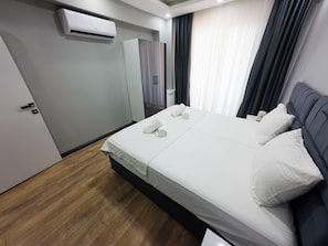 Quarto de hotel com cama, guarda-roupa, ar condicionado e espelho.