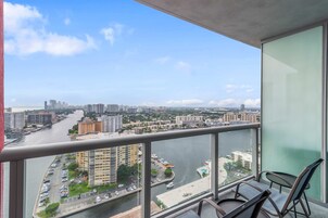 Varanda com vista para paisagem urbana, incluindo edifícios e um rio.