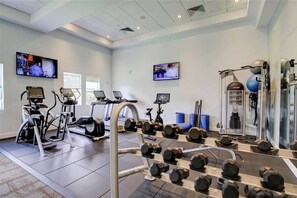Academia com esteiras, bicicletas ergométricas e equipamentos de musculação.