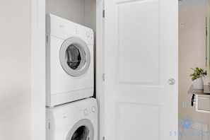 Máquina de lavar e secar embutida na parede, com porta à direita.