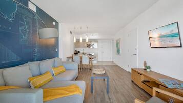 Uma sala de estar moderna com sofá, mesa de centro e um espaço de refeições com cadeiras e mesa.