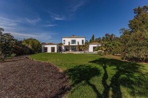 Uma casa grande de dois andares com um gramado bem cuidado e piscina.