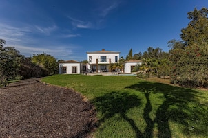 Uma casa grande de dois andares com um gramado bem cuidado e piscina.
