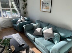 Sala de estar com sofá, mesa de centro e quadro na parede.
