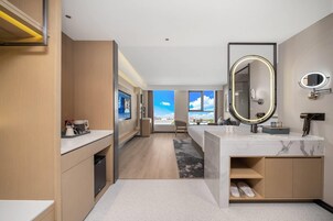 Casa de banho de hotel moderna com um espelho grande, toucador e vista para a cidade.