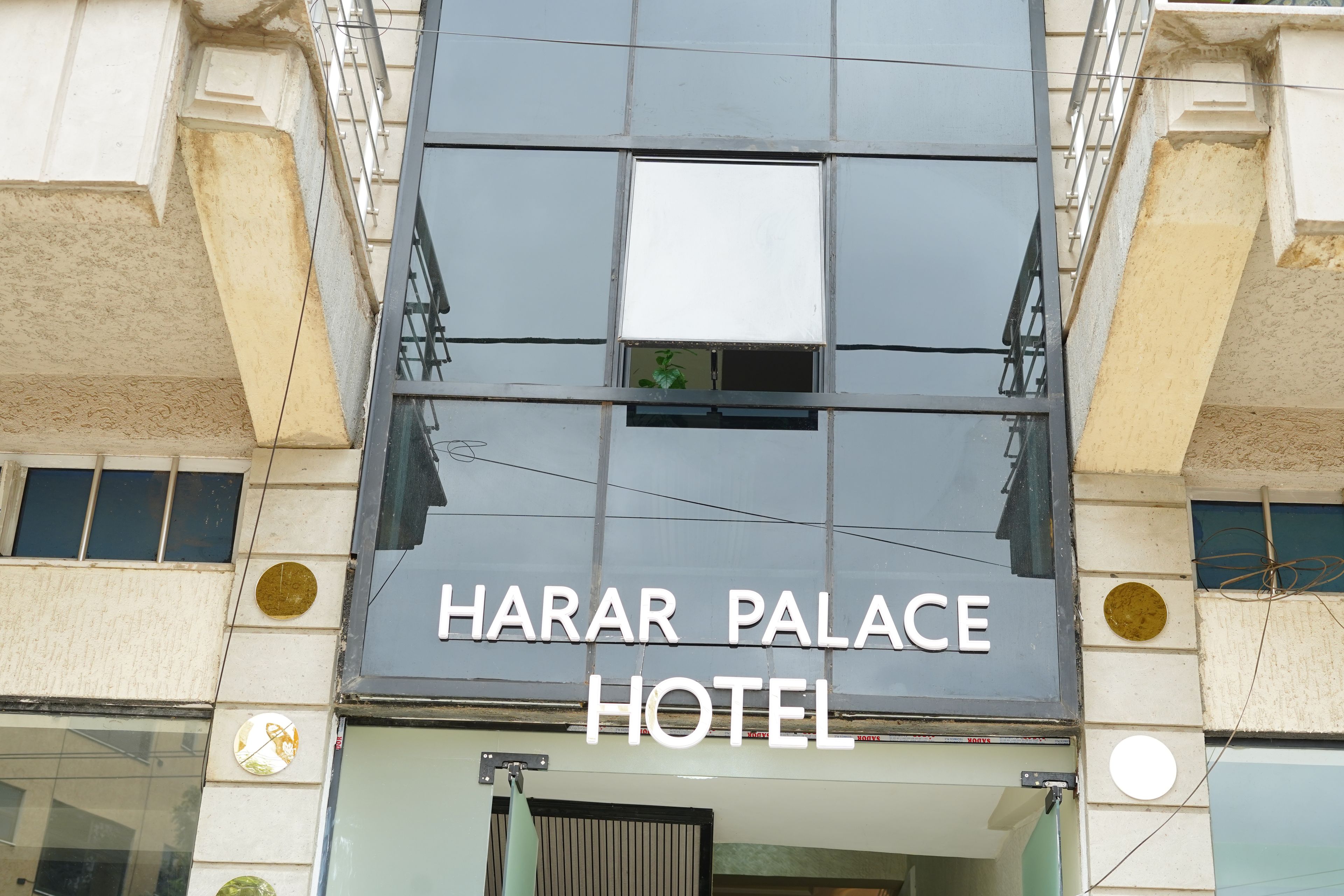 Um edifício com uma placa que diz 'HARAR PALACE HOTEL'.