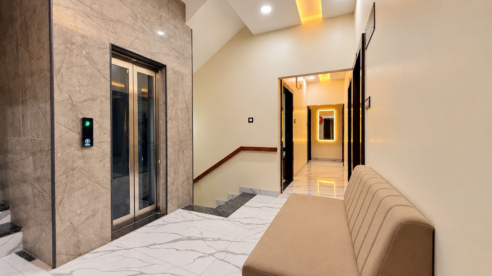 Um hall de hotel moderno, com piso de mármore, um sofá e um elevador.