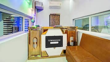 Um interior moderno com uma mesa de recepção identificada com 'TOWNHOUSE' e um sofá de couro.