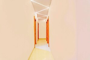 Um corredor com teto inclinado e portas de madeira.