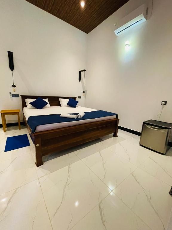 Quarto com cama de madeira, piso de mármore branco e ventilador de teto.
