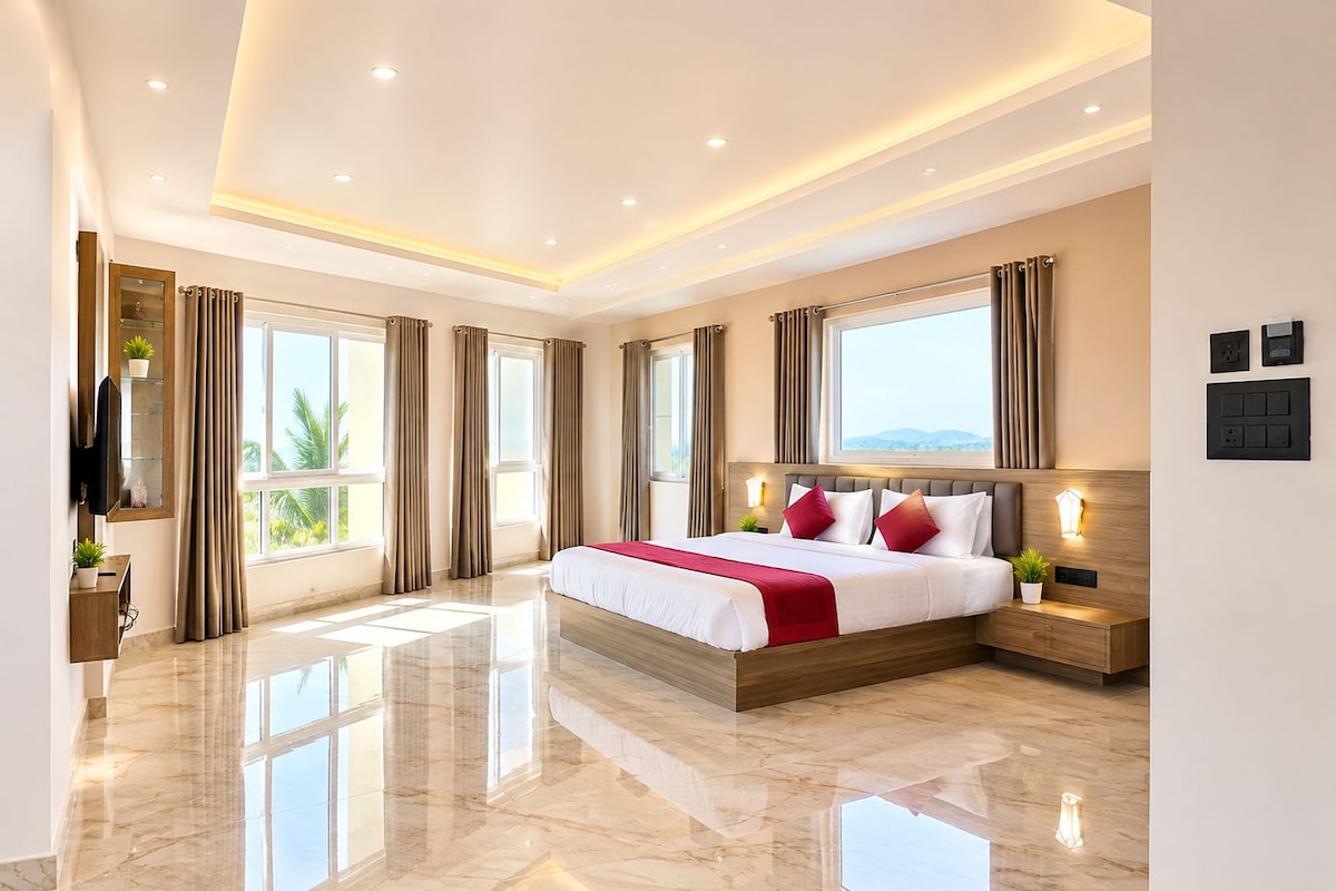 Quarto de hotel espaçoso com uma cama grande, televisão de tela plana e vista para o exterior.