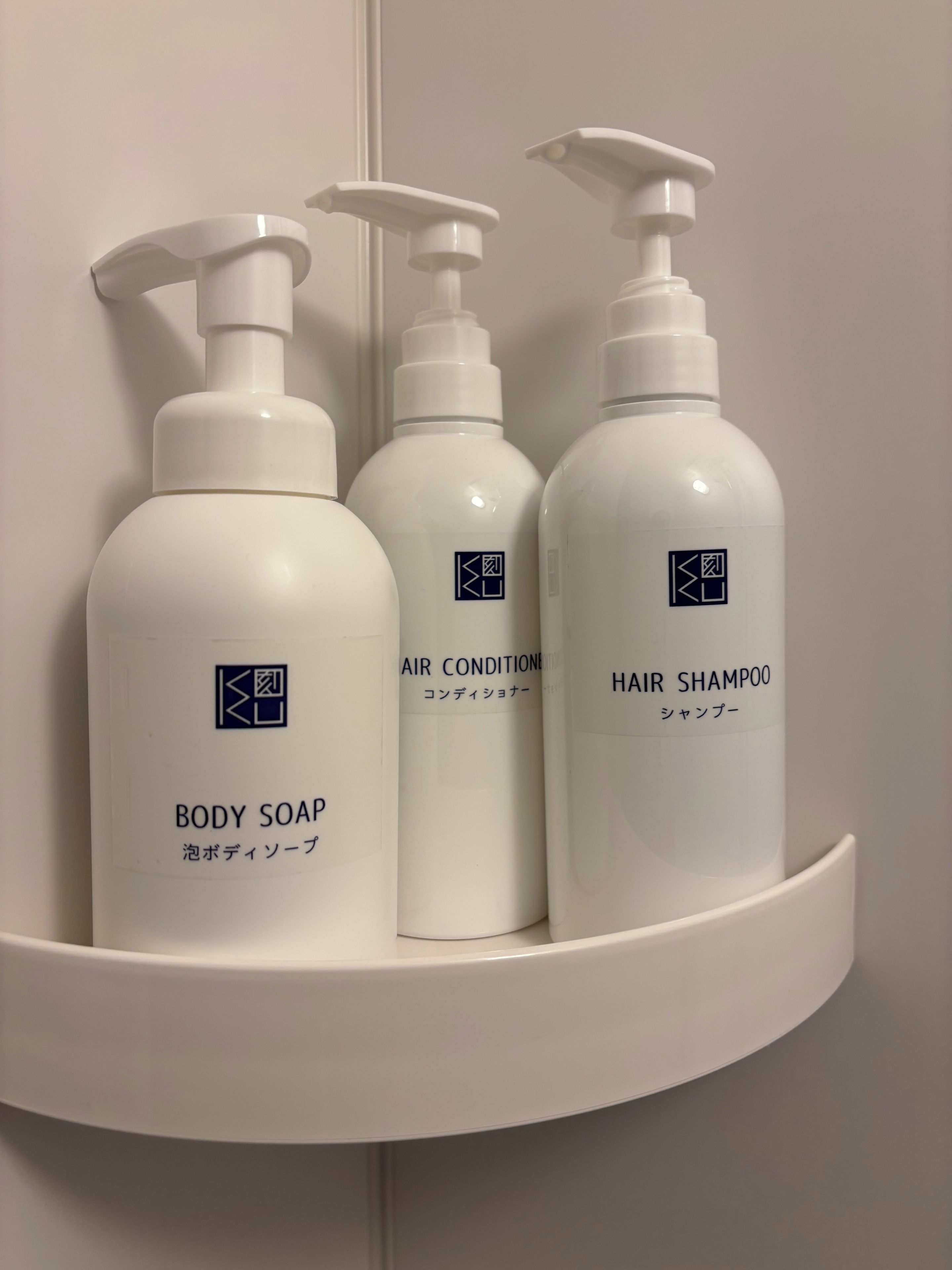 Estante branca com três frascos de produtos de higiene pessoal.