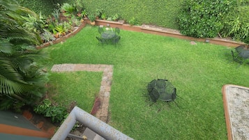 Um jardim bem cuidado com gramado, plantas em vasos e móveis de exterior.