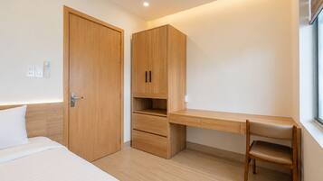 Quarto com cama, escrivaninha, cadeira e guarda-roupa.