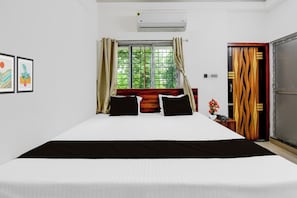 Quarto de hotel com cama, janela com cortinas, ar condicionado e porta com design exclusivo.