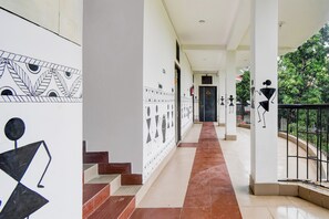 Um corredor com paredes padronizadas, uma escada e um corrimão.