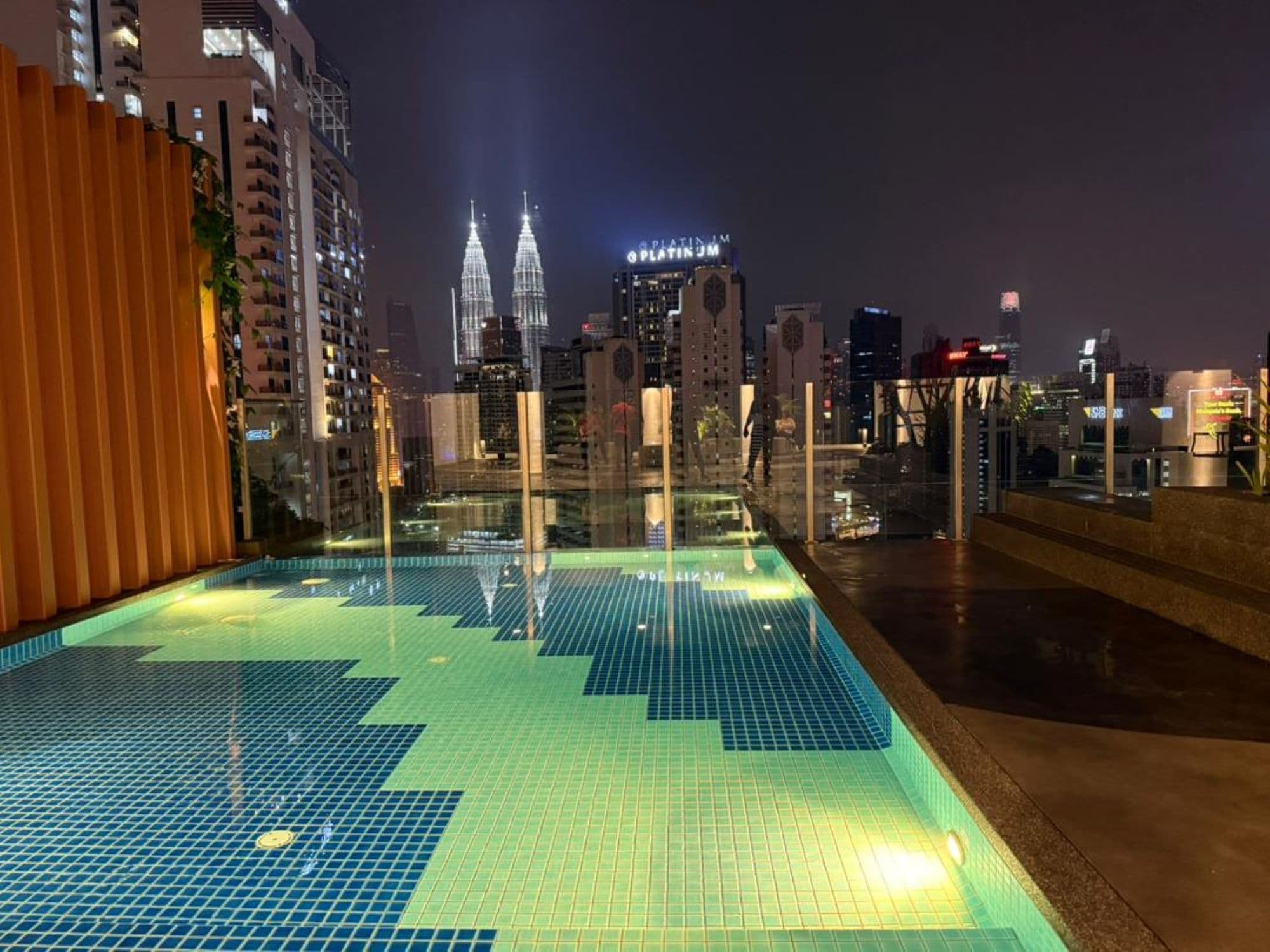 Piscina no terraço com vista para o horizonte da cidade, incluindo as Torres Petronas.