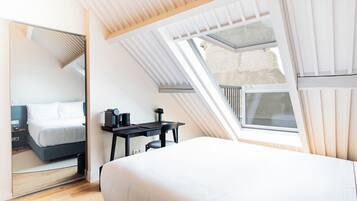 Quarto com uma cama, uma escrivaninha e uma janela com vista para o exterior.