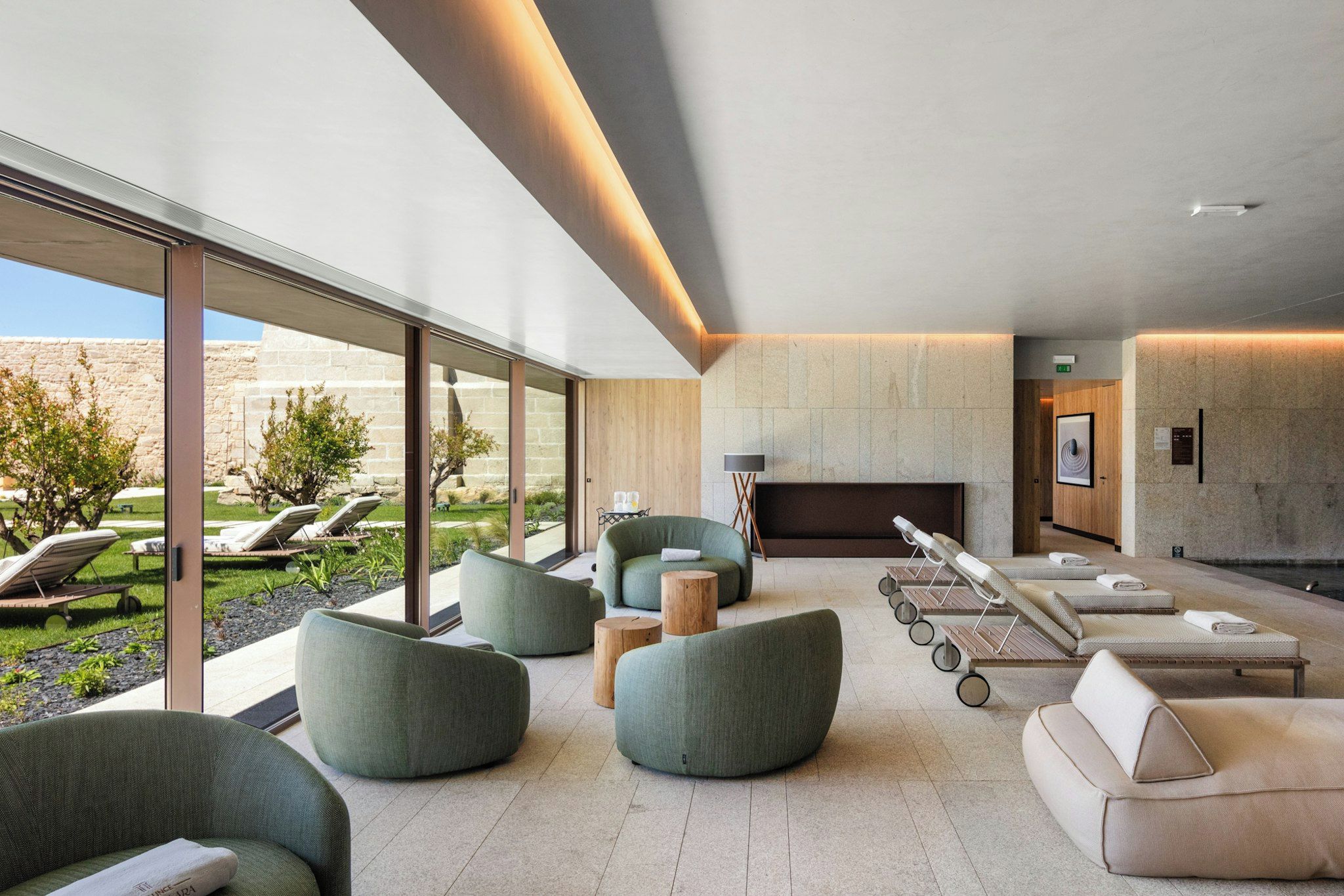 Uma área de estar moderna com assentos, lareira e vista para o exterior.