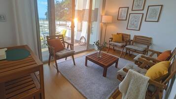 Uma sala de estar moderna com uma mesa de centro de madeira, dois sofás e uma mesa de jantar.