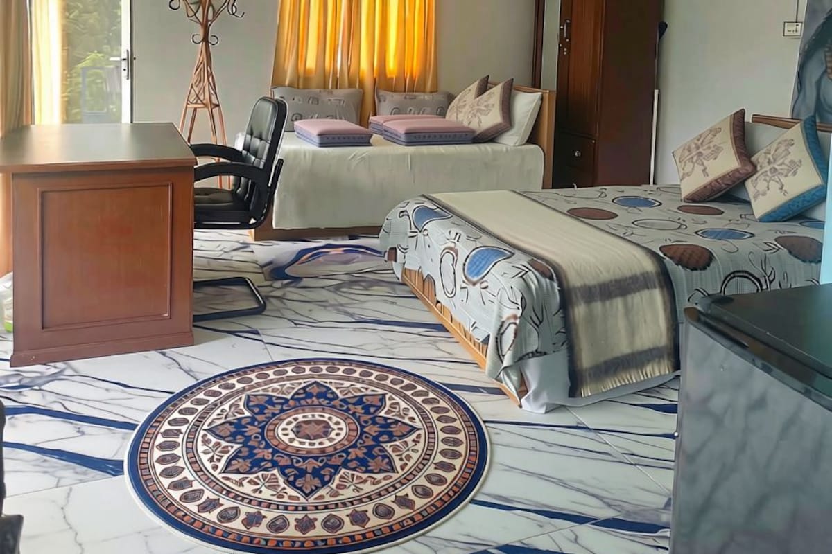 Quarto com cama, escrivaninha, cadeira, guarda-roupa e tapete estampado.