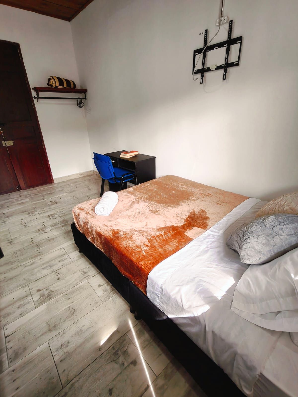 Quarto com cama, escrivaninha e cadeira.