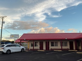 Um edifício com telhado vermelho e uma placa que diz 'Sunshine Inn'.