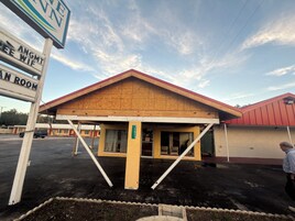 Um motel com teto vermelho e entrada coberta.