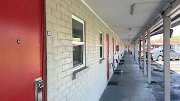 Uma fileira de quartos de motel, com uma porta vermelha e janela no primeiro quarto.