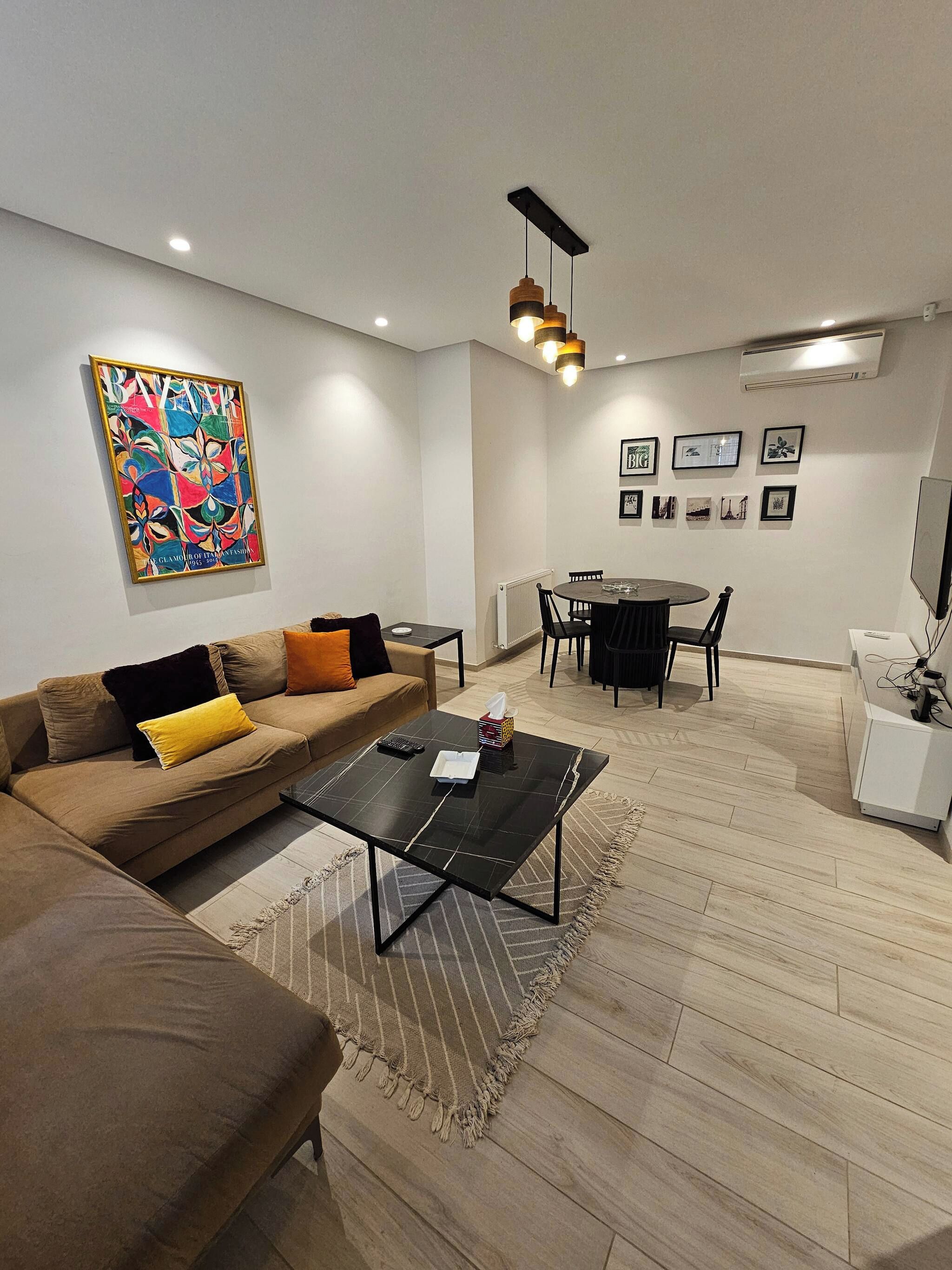 Uma sala de estar moderna com sofá, mesa de centro e área de jantar.