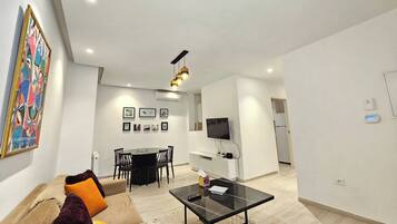 Uma sala de estar moderna com sofá, mesa de centro e espaço para refeições.