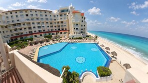 Hotel com piscina grande, acesso à praia e vista para o oceano.