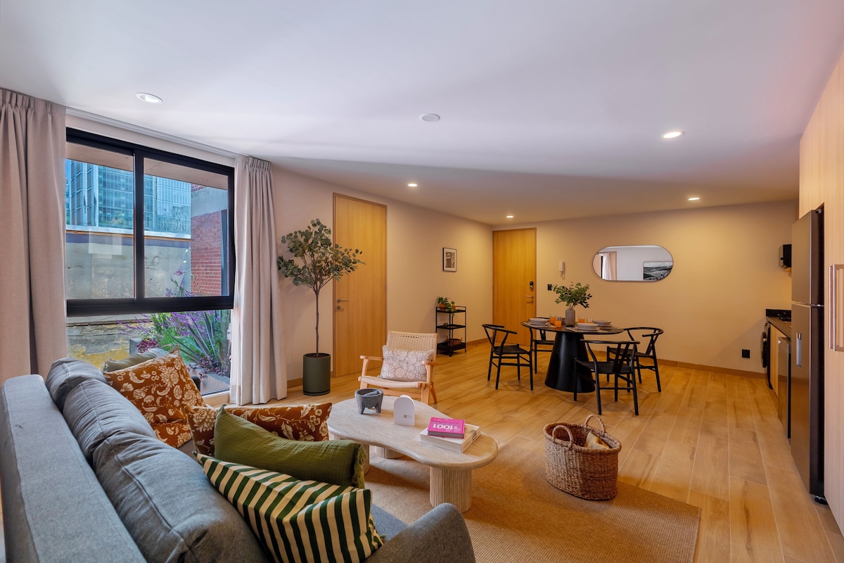 Uma sala de estar moderna com sofá, mesa de centro e área de jantar.
