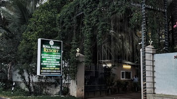 Placa de identificação do Royal Nature Resort com comodidades como piscina, áreas de jogos e salão de eventos.
