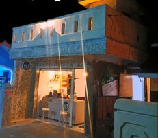 Um edifício com uma placa indicando 'HST' e uma área de bar com banquetas.